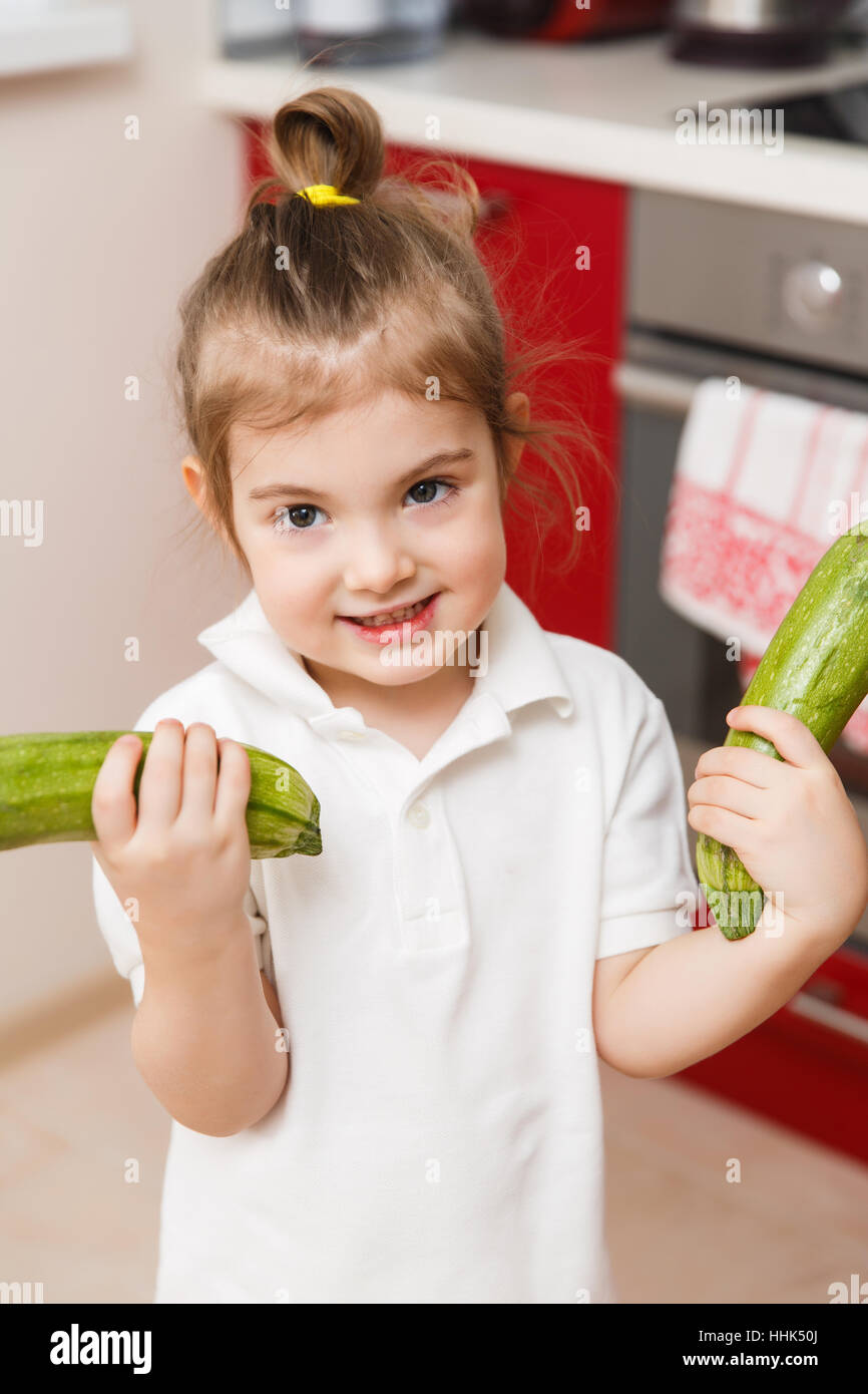 Little child with two zucchini Stock Photo - Alamy