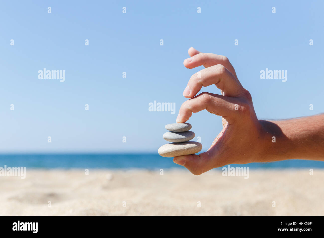 Hand holds stones on beach Stock Photo - Alamy