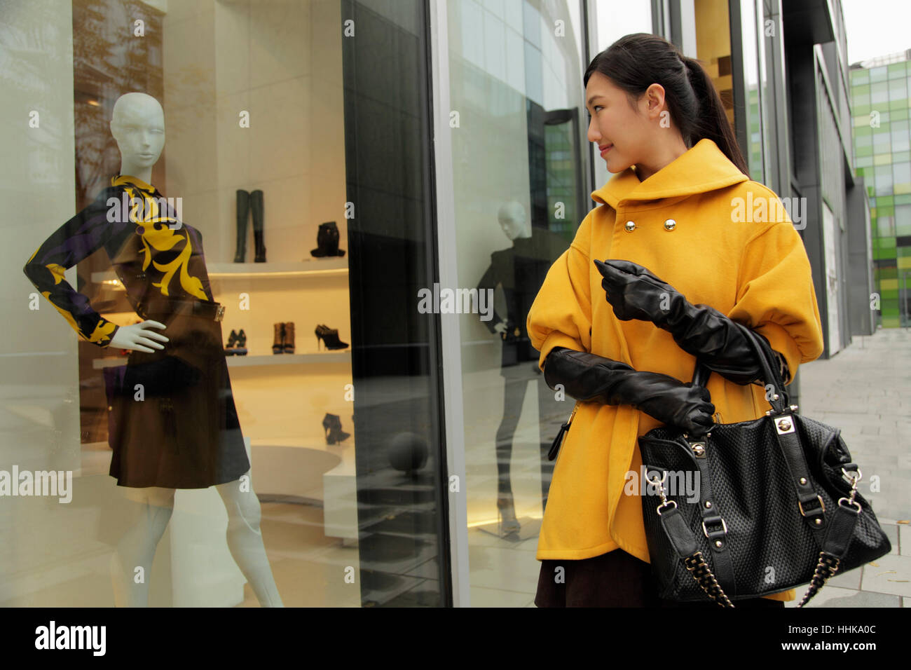 Young woman looking in shop window Stock Photo - Alamy