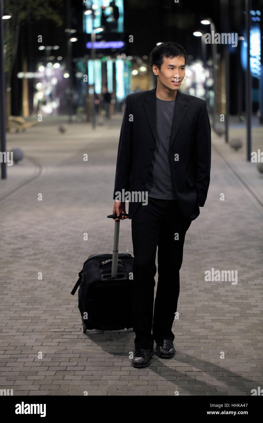 Asian man pulling suitcase hi-res stock photography and images - Alamy