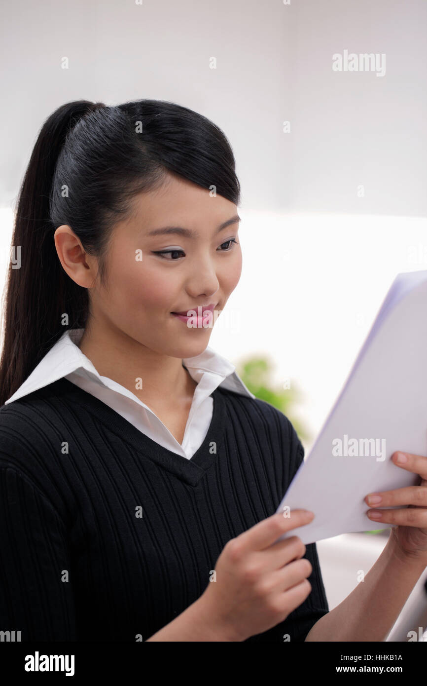 Head shot of young woman looking at paper Stock Photo - Alamy