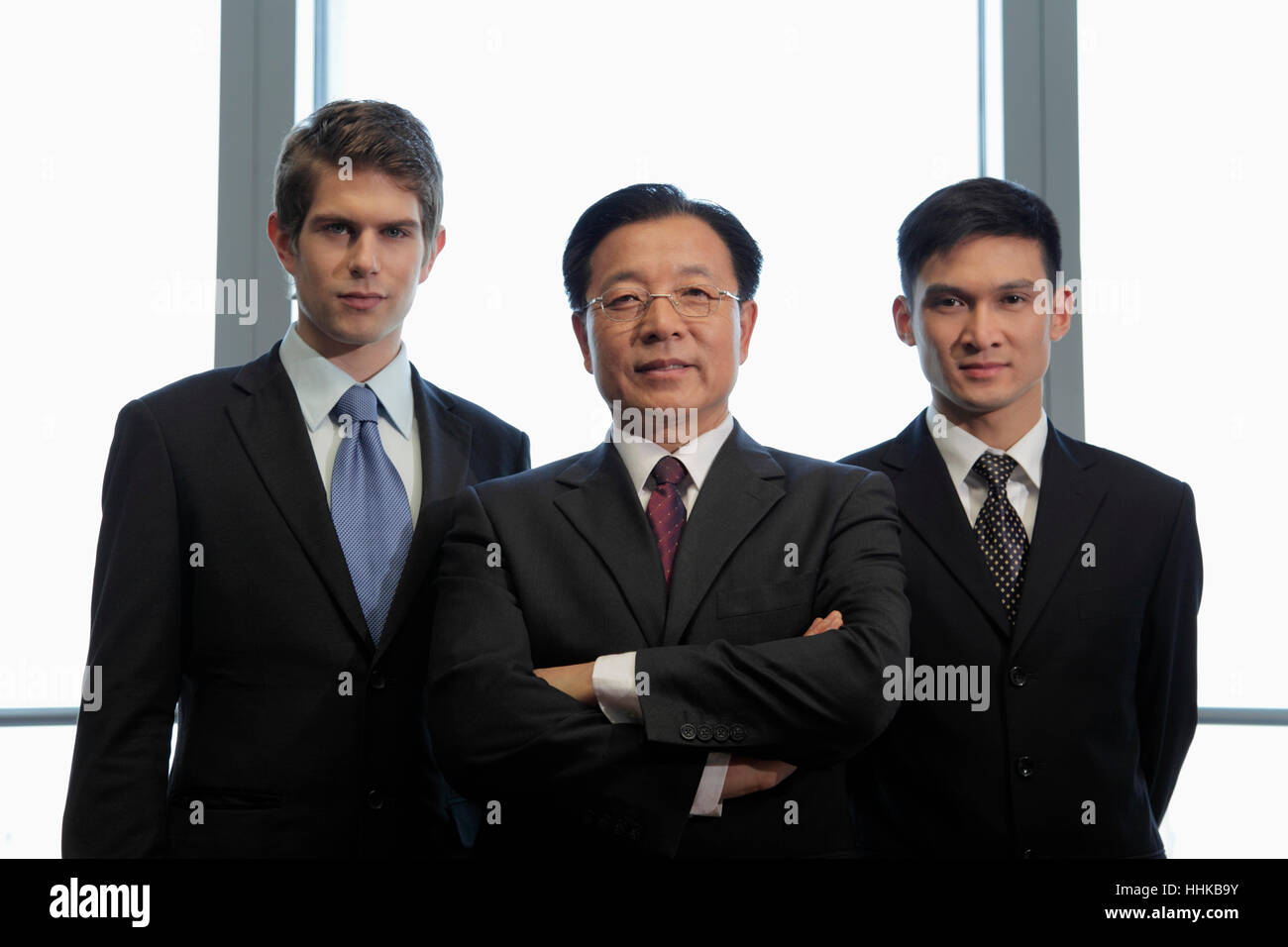Three businessmen standing together Stock Photo - Alamy