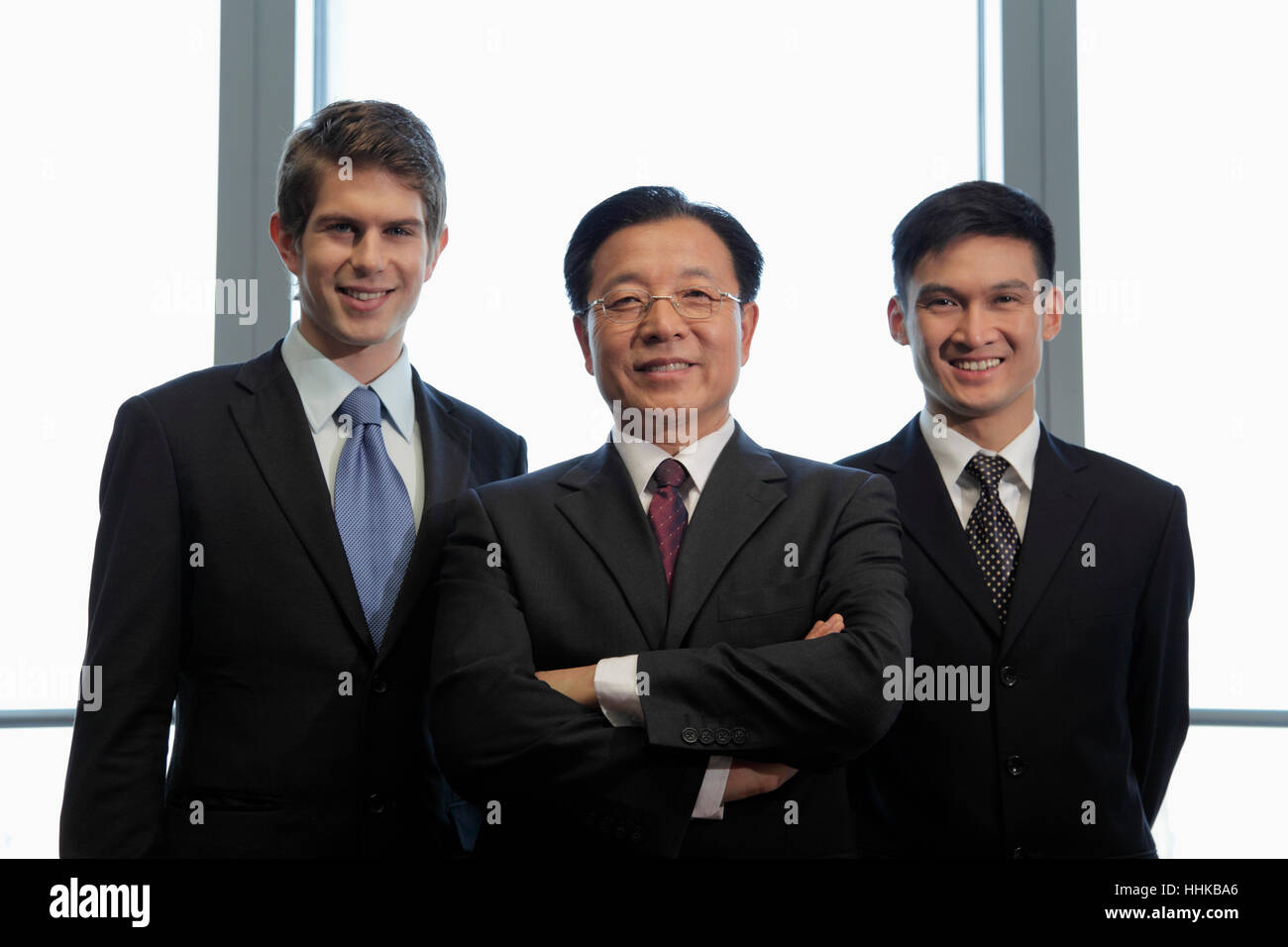 Three businessmen standing together Stock Photo - Alamy