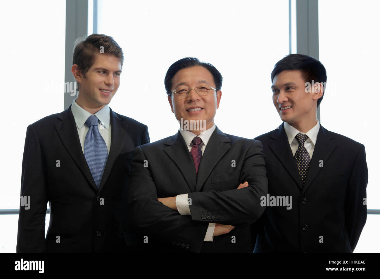 Three businessmen standing together Stock Photo - Alamy