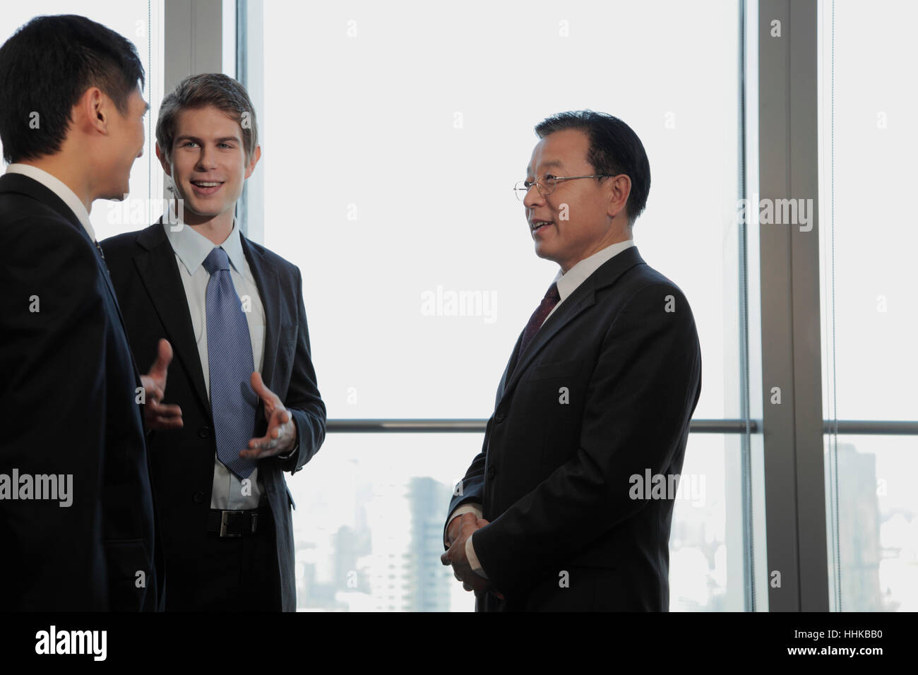 Three businessmen talking together Stock Photo - Alamy