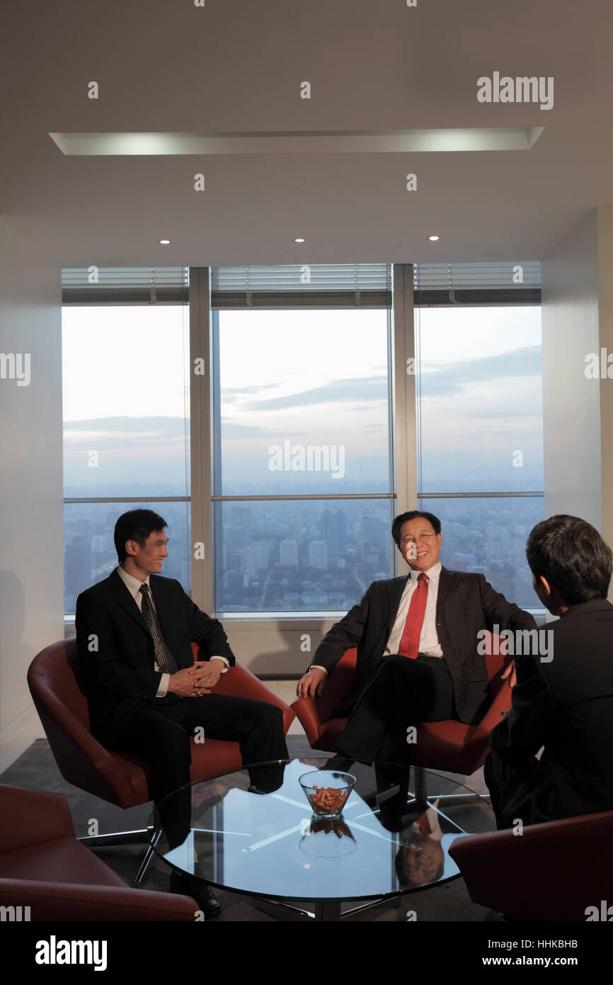Three businessmen talking in an office Stock Photo - Alamy