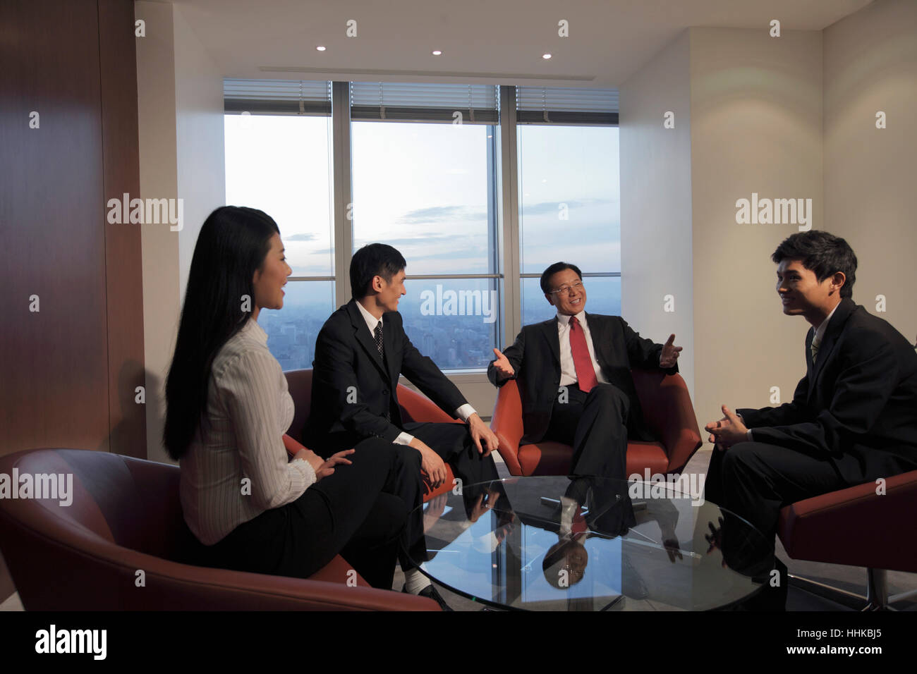 Four people having a meeting in an office Stock Photo - Alamy