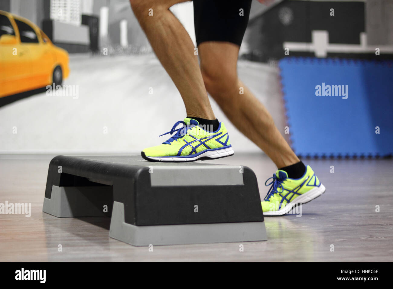 Man doing step up jumps in health club Stock Photo - Alamy