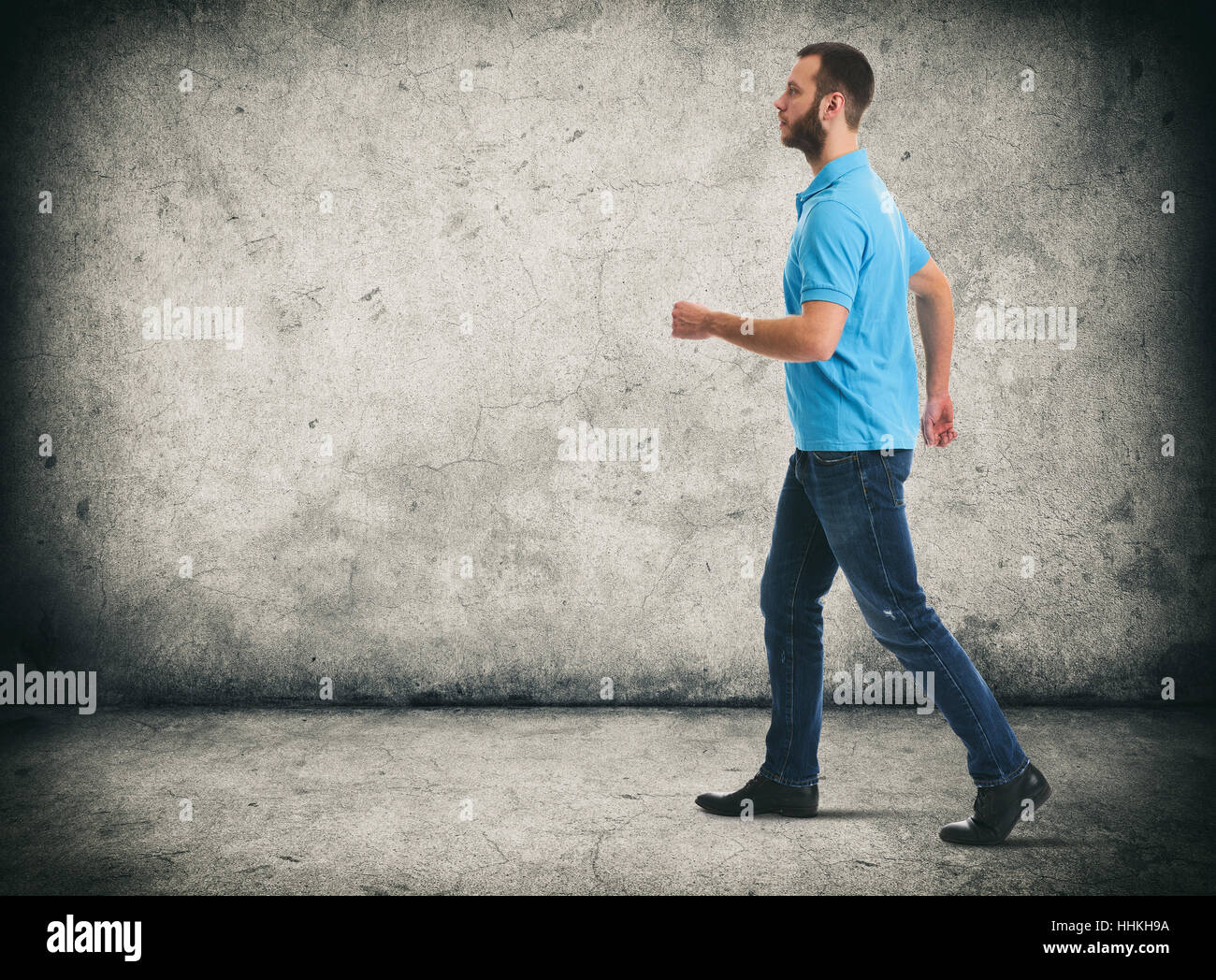 full length portrait of walking bearded man. Grunge urban background ...