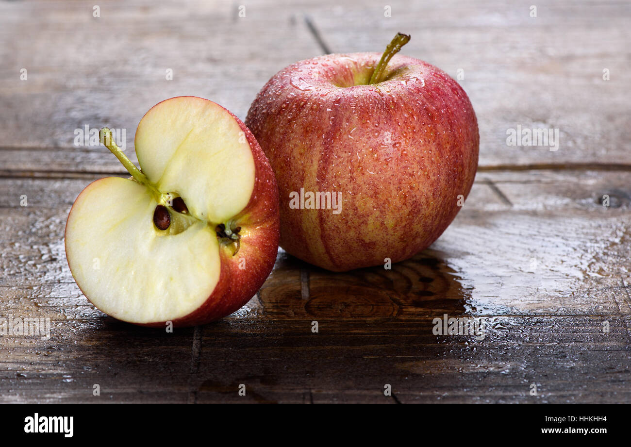 wet fresh red apple on rustic wooden table Stock Photo - Alamy