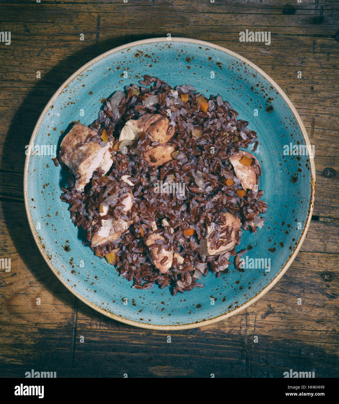 plate of brown rice with chicken on rustic wooden table Stock Photo - Alamy