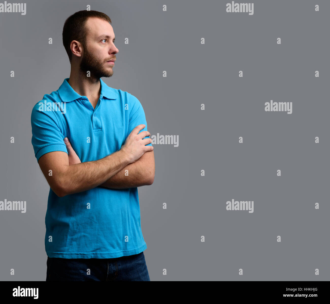 casual caucasian bearded guy looking away. Isolated on grey background ...