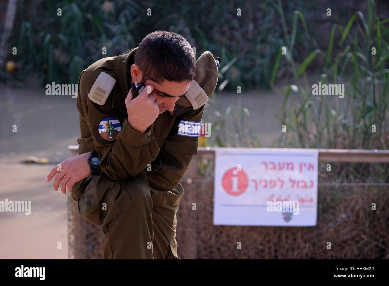 An Israeli soldier stands next to a warning sign which reads" no ...