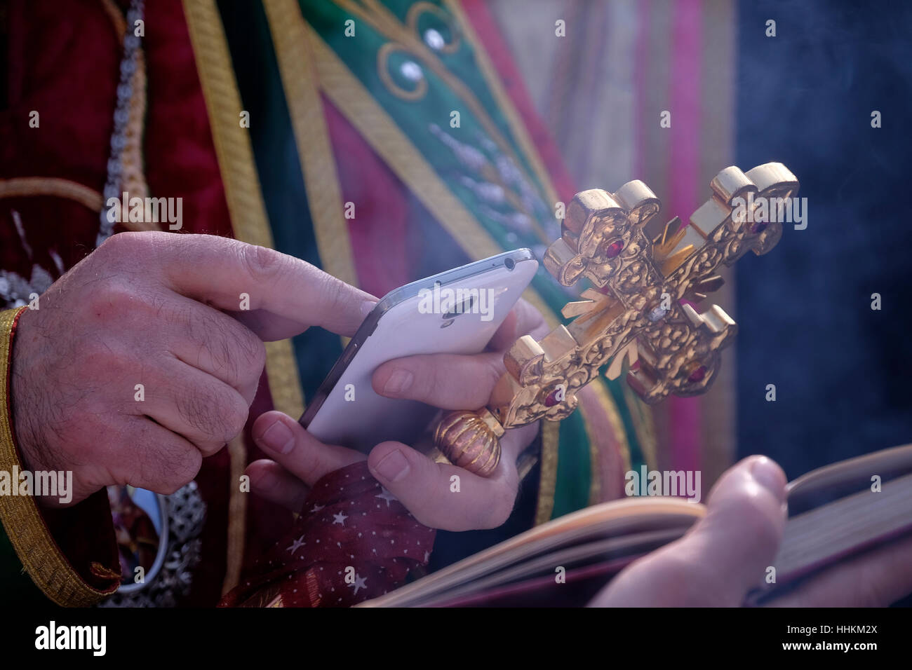 A Syriac Orthodox cleric using a smart phone as he leads a religious ...
