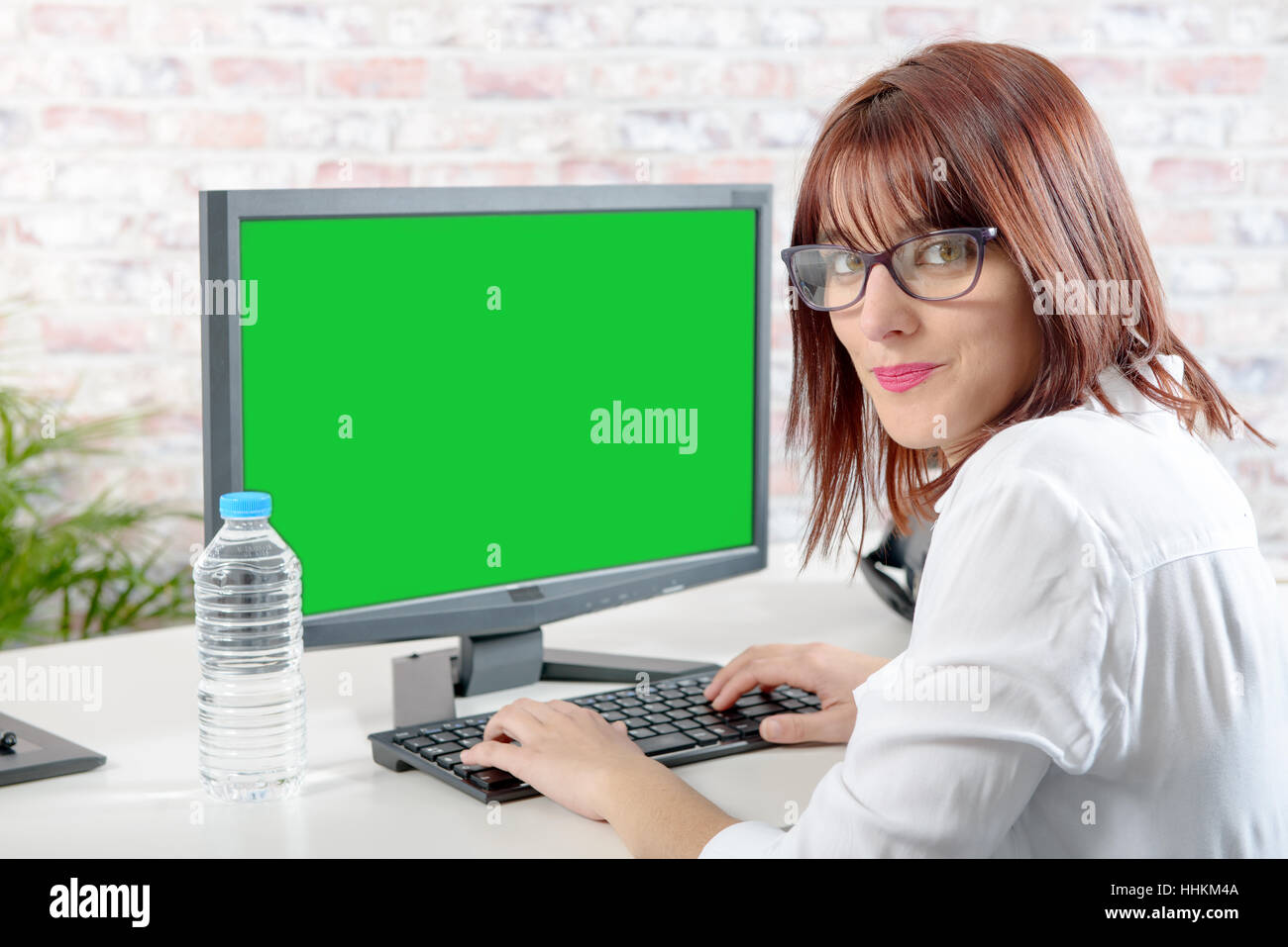 pretty young business woman working at pc with green screen Stock Photo ...
