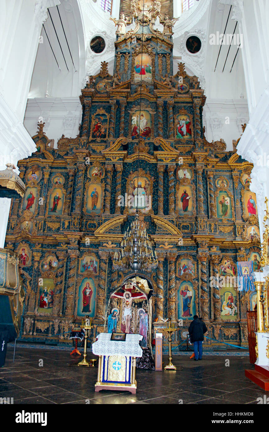 people in the church near beautiful iconostasis with ancient icons set in wooden frame ...