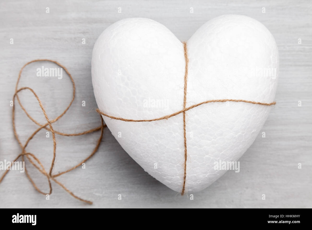 Heart bound by a string on grey rustic background Stock Photo - Alamy
