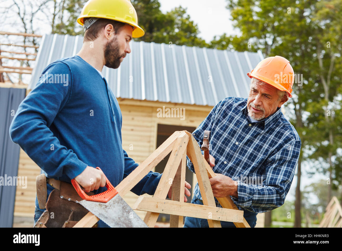 Two craftsmen working in team and cutting wood Stock Photo - Alamy