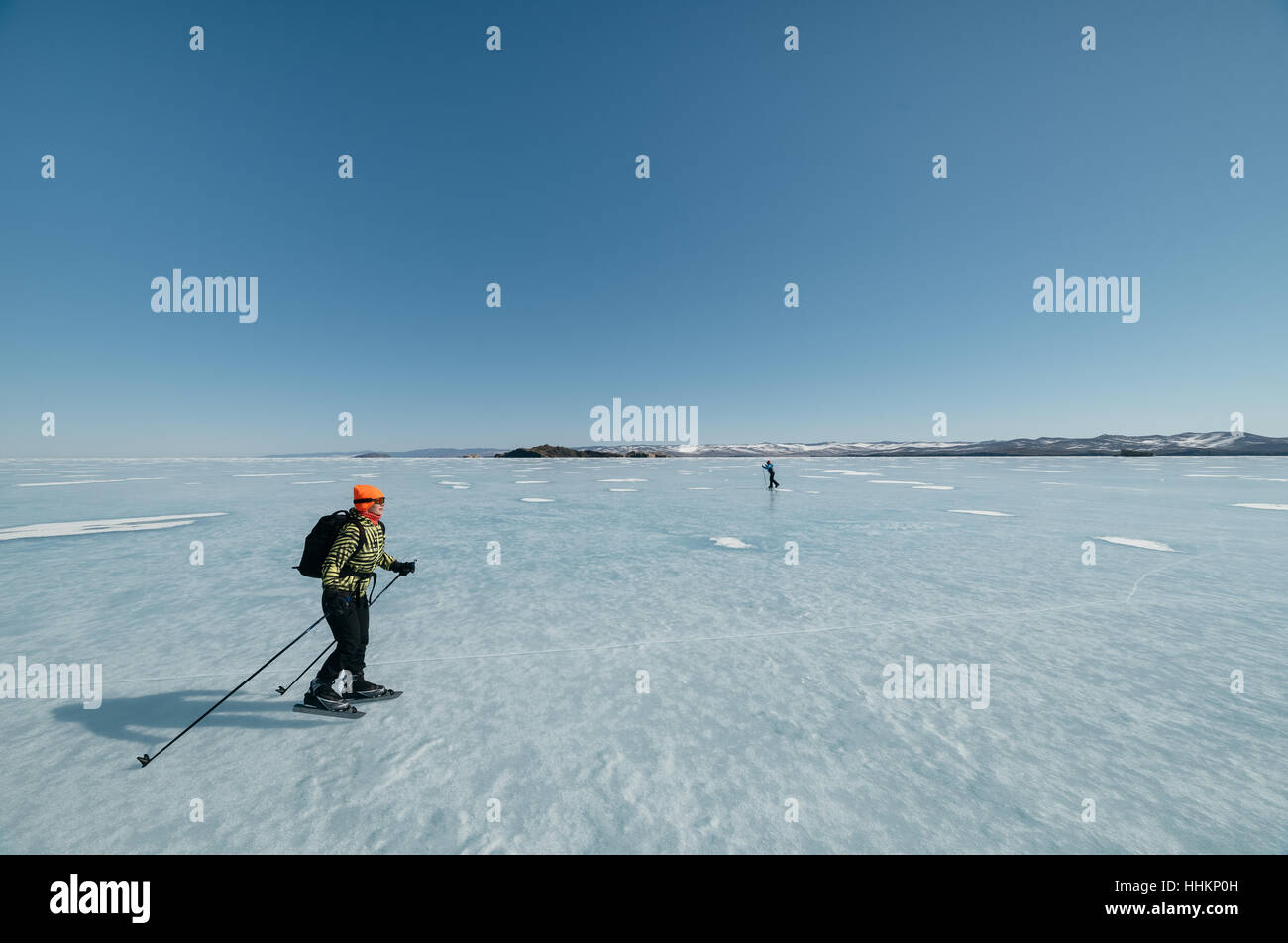 Tourists travel to Norway hiking ice skating on the frozen lake ...
