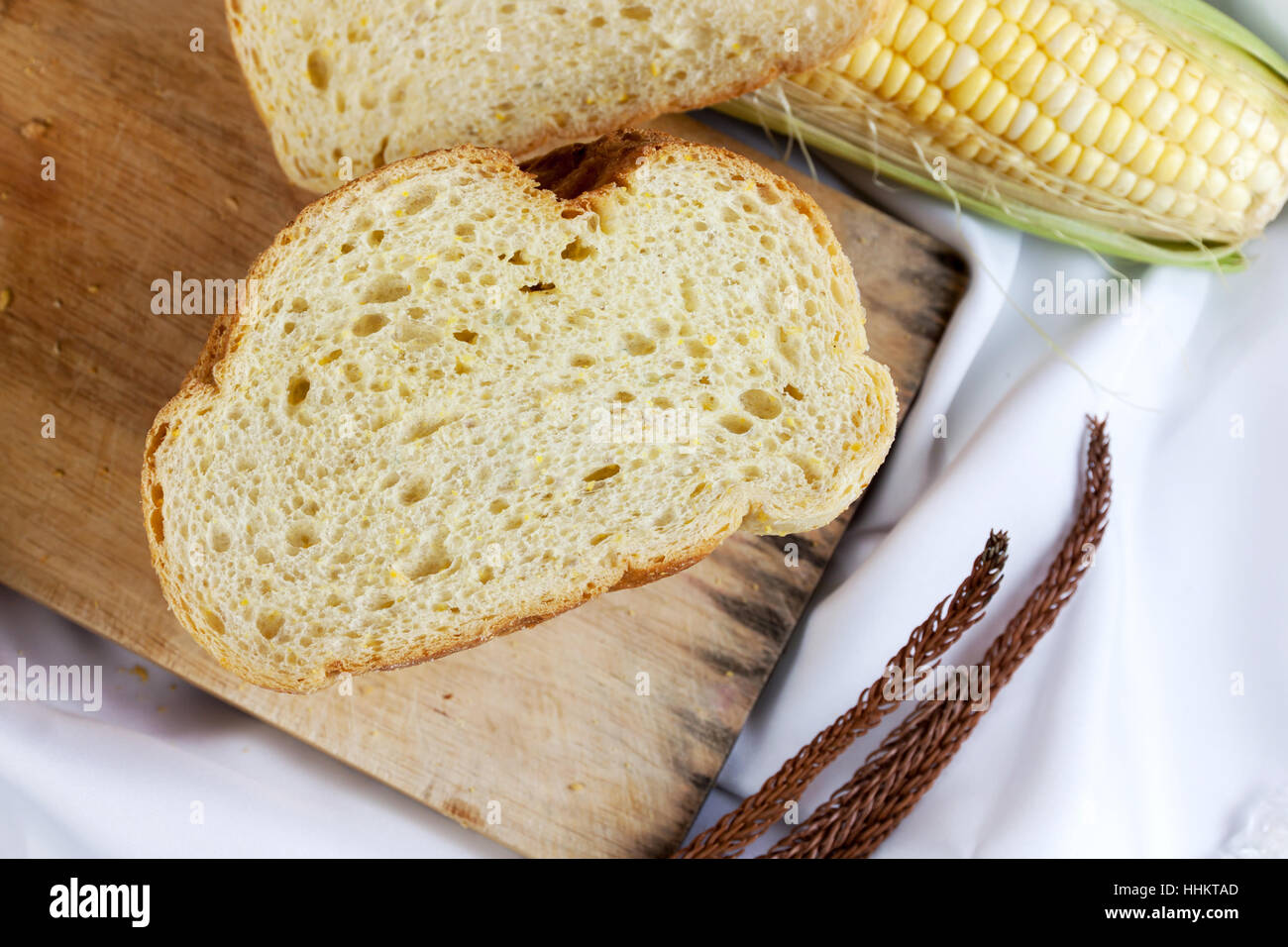 bread made from corn on the white fabric. Slices of corn bread laying ...