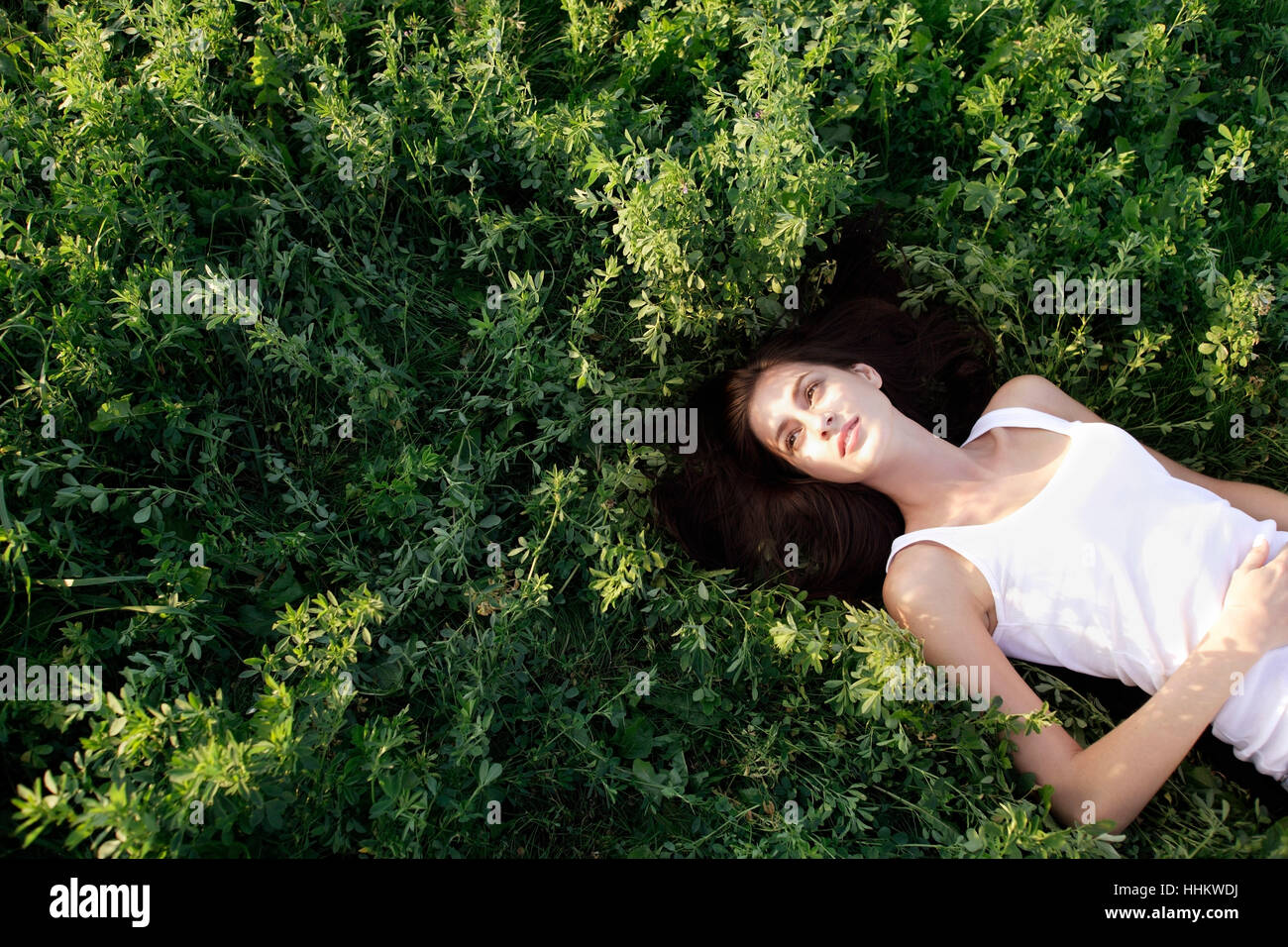 Young woman lying on her back in field Stock Photo - Alamy