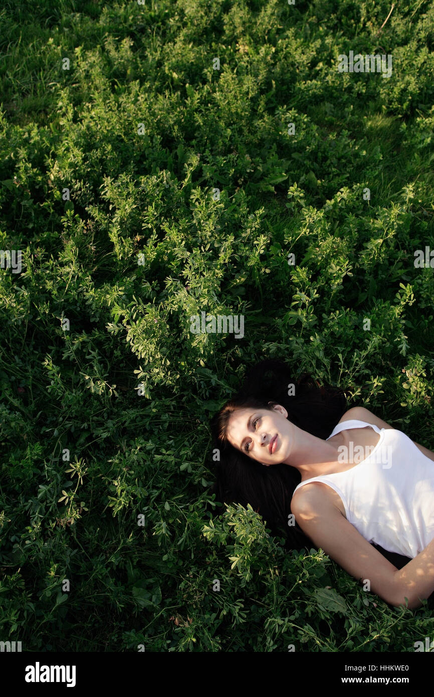 Young woman lying on back in field Stock Photo - Alamy