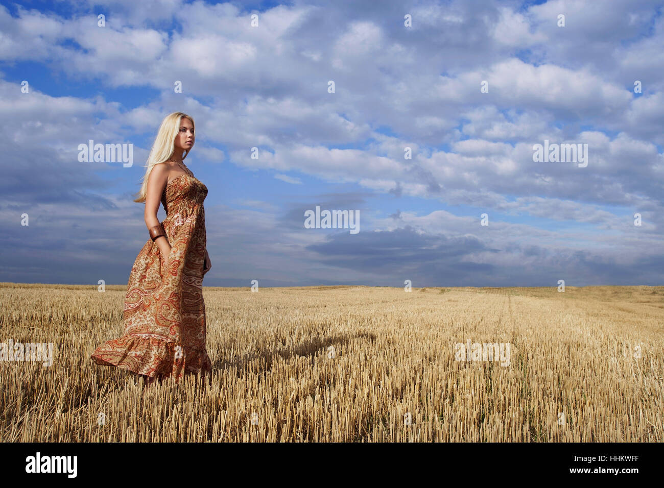 Young woman standing in field Stock Photo - Alamy