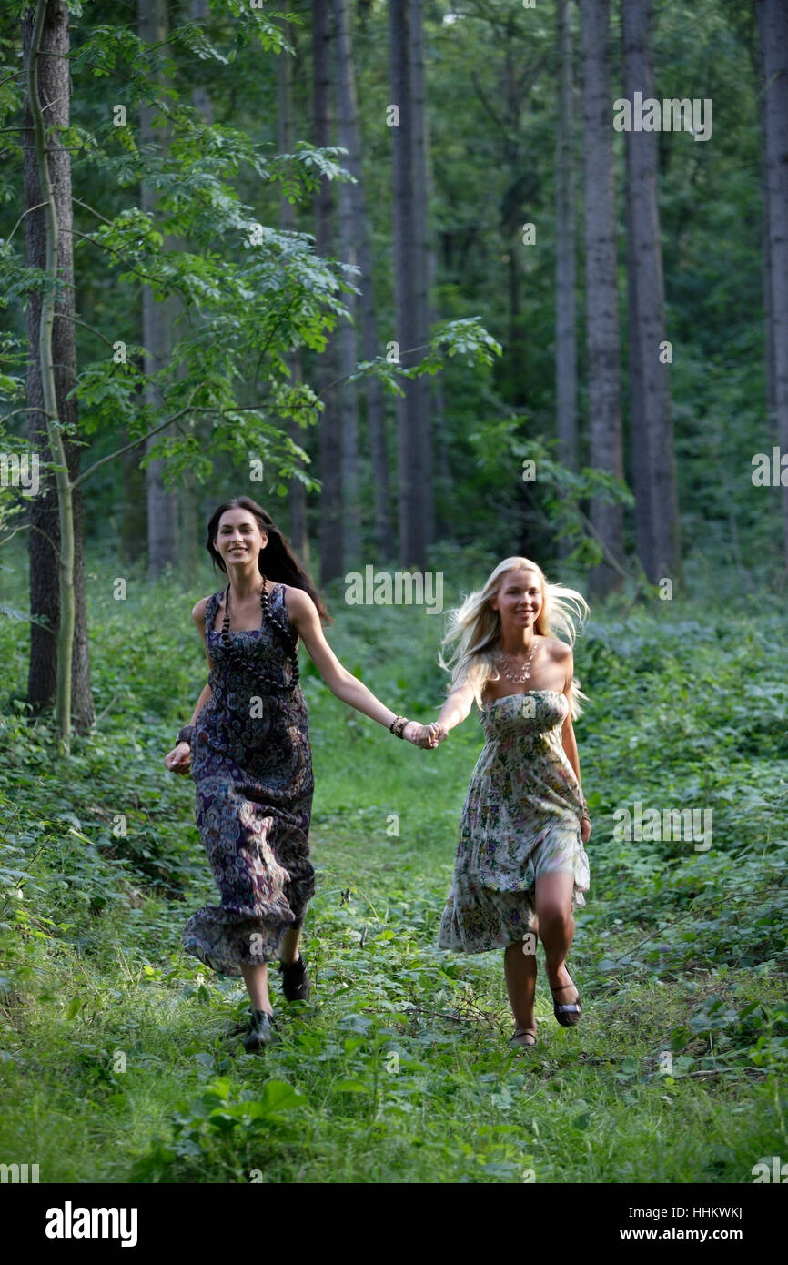 Young women running through forest Stock Photo - Alamy