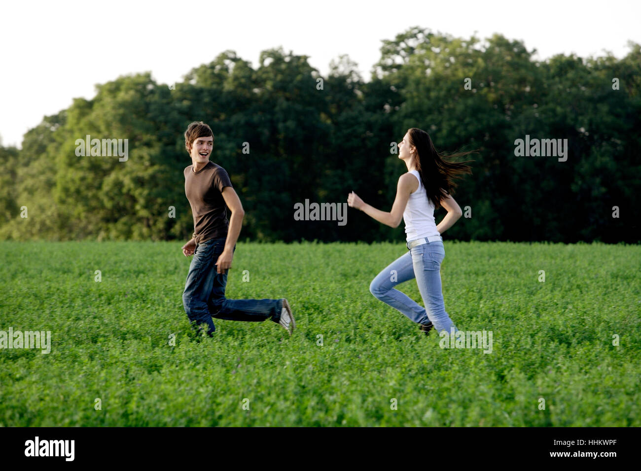 Young couple running in field Stock Photo - Alamy
