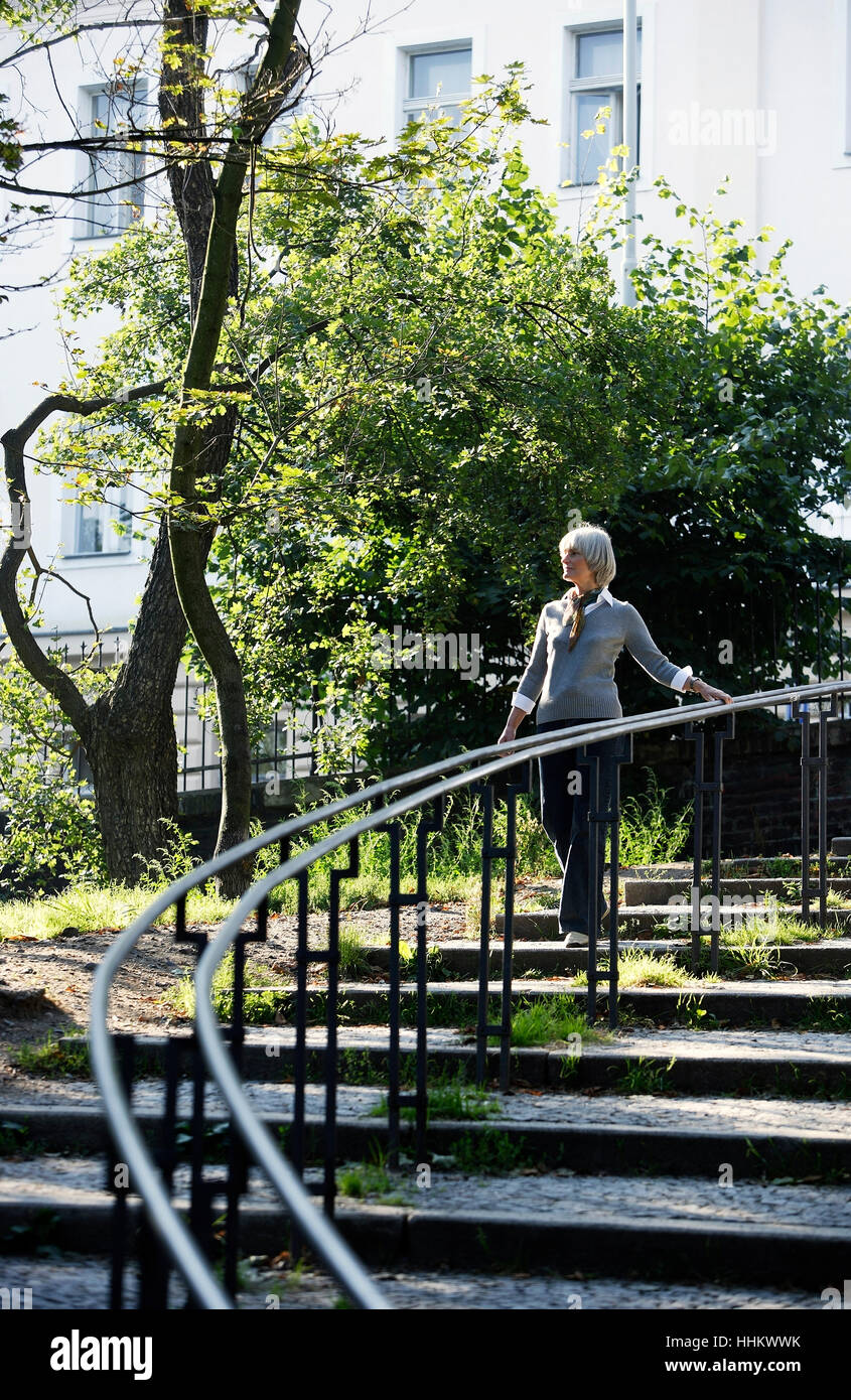 Senior woman walking down steps Stock Photo - Alamy