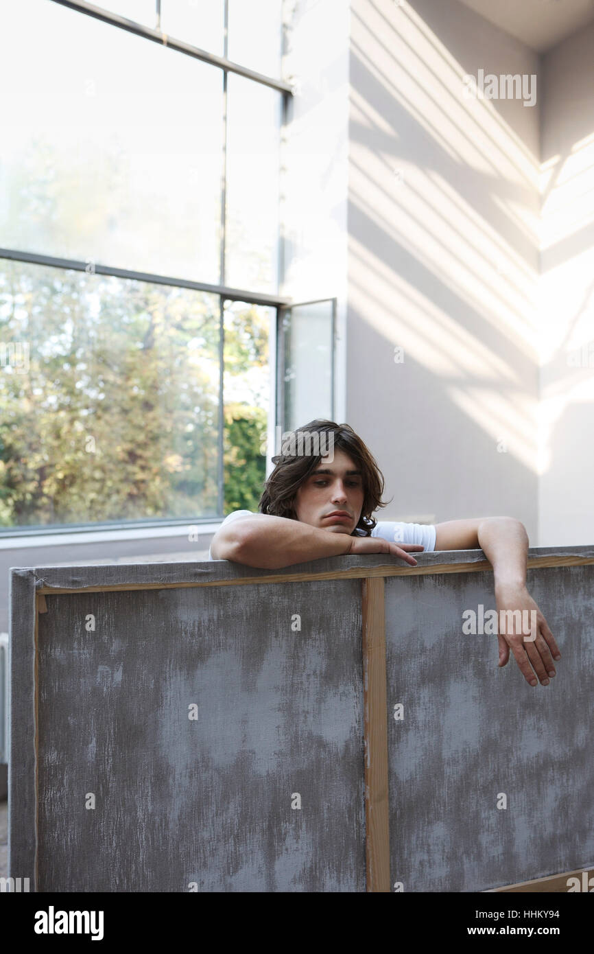 artist leaning on canvas Stock Photo - Alamy