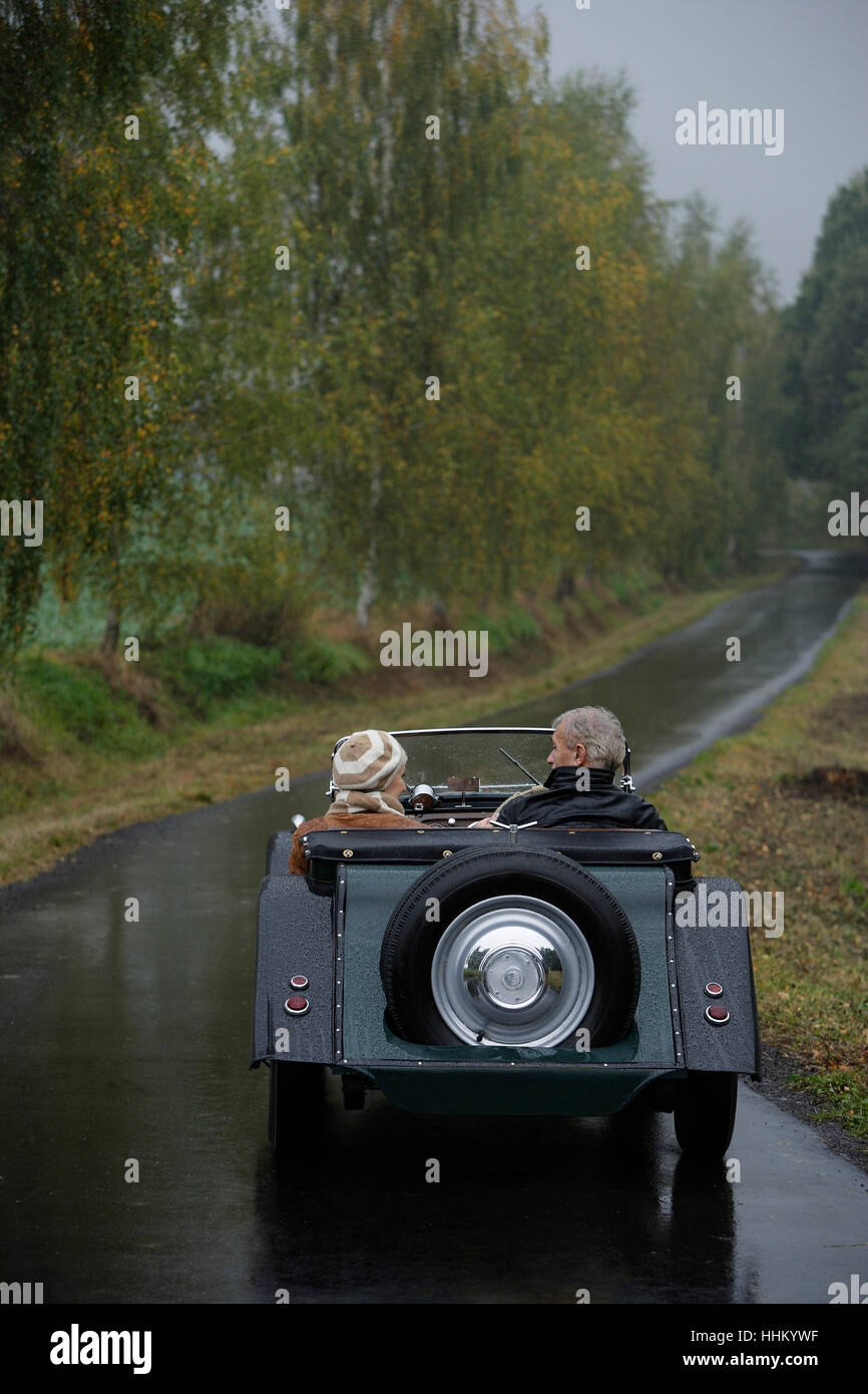 Senior couple driving down country road in antique car Stock Photo - Alamy