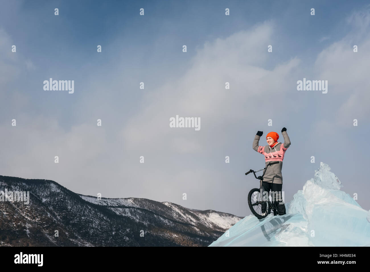 Girl standing on a bmx on the beautiful and dangerous ice and enjoys a ...