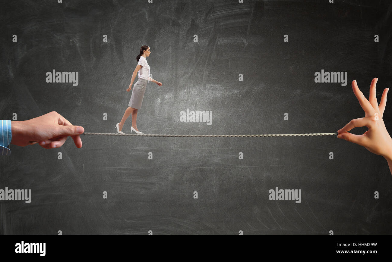 Confident businesswoman walking on rope strained in hands Stock Photo ...