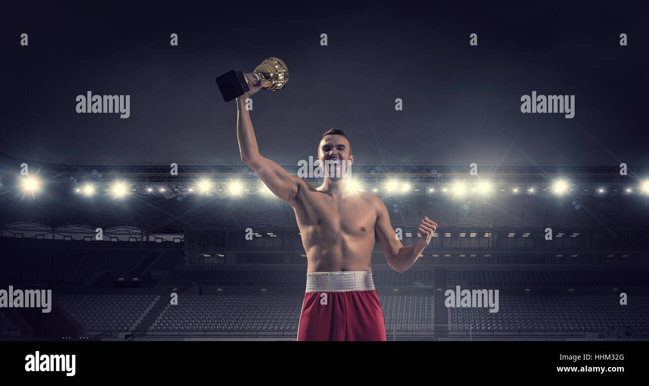 Emotional boxer rising cup in hand and celebrating victory. Mixed media ...