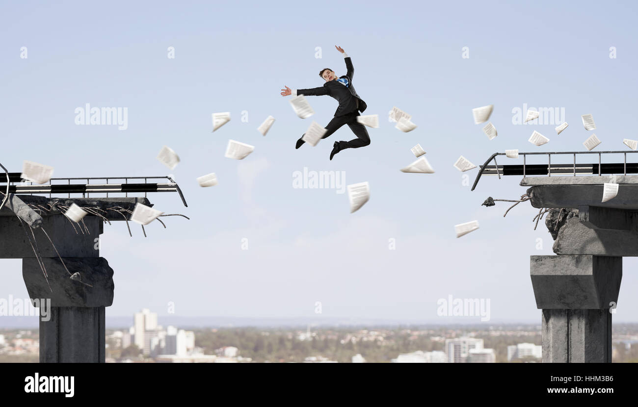 Businessman jumping over a gap in bridge as symbol of problem ...