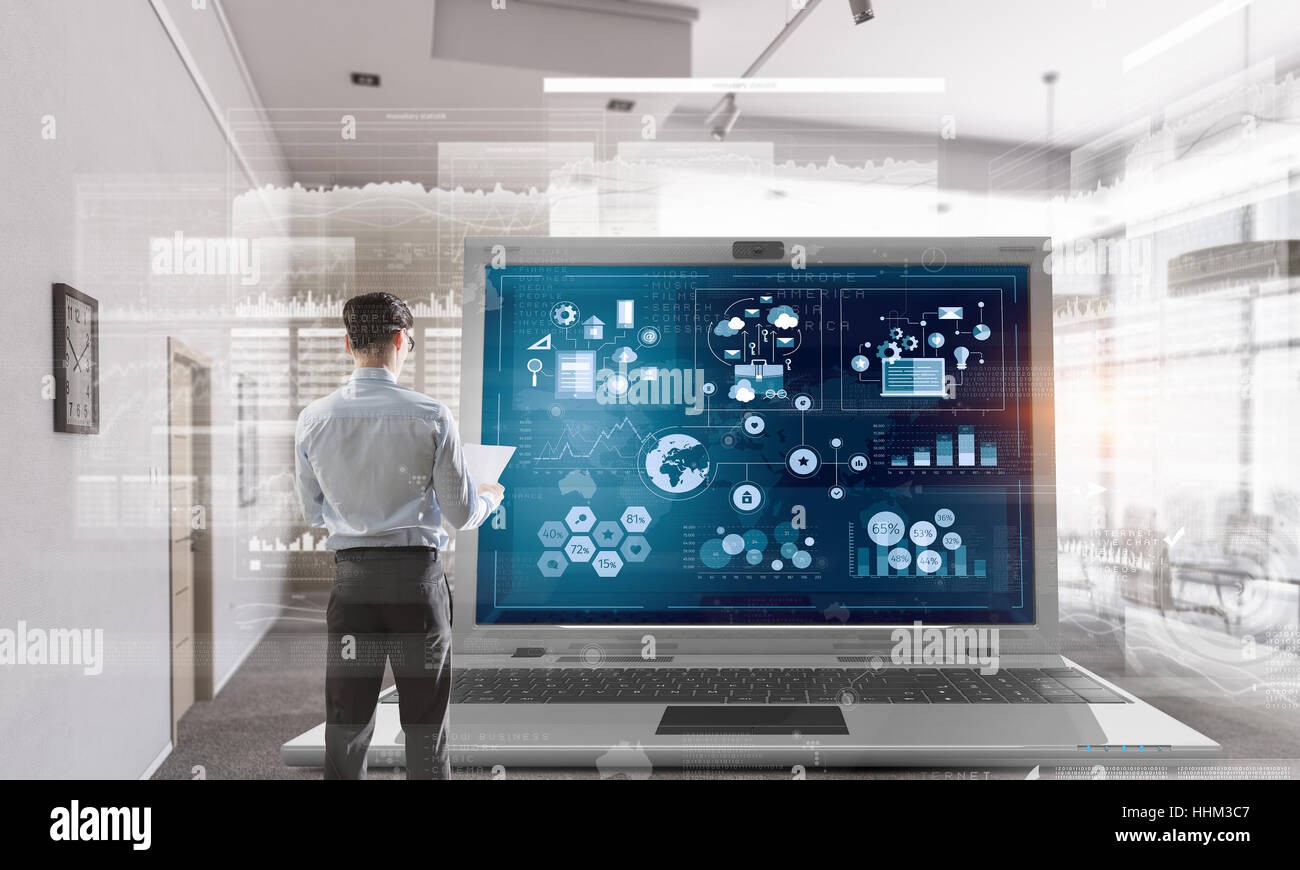 Young businessman and huge laptop with infographs on screen. Mixed ...