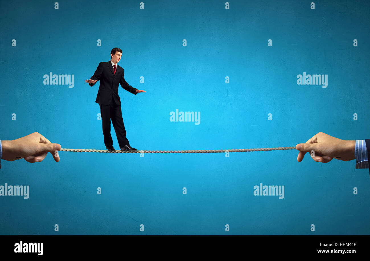Careful businessman walking on rope strained in hands Stock Photo - Alamy