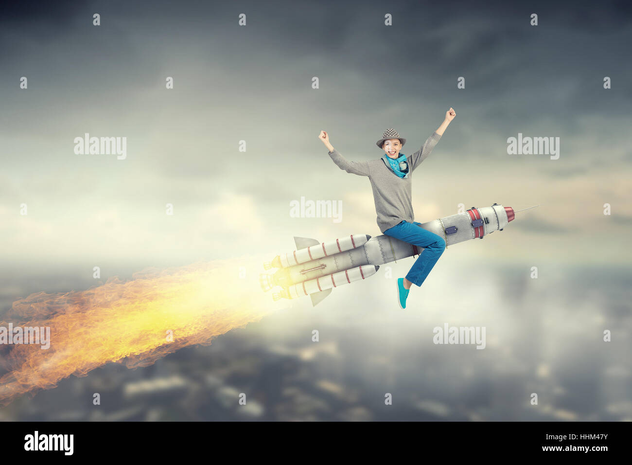 Young cheerful woman traveller riding rocket high in sky Stock Photo ...