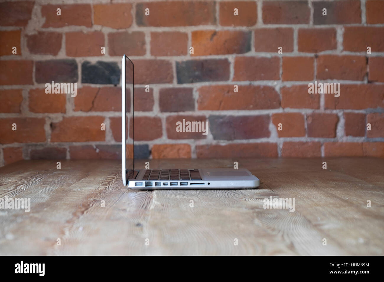 Open laptop computer against brick wall Stock Photo - Alamy