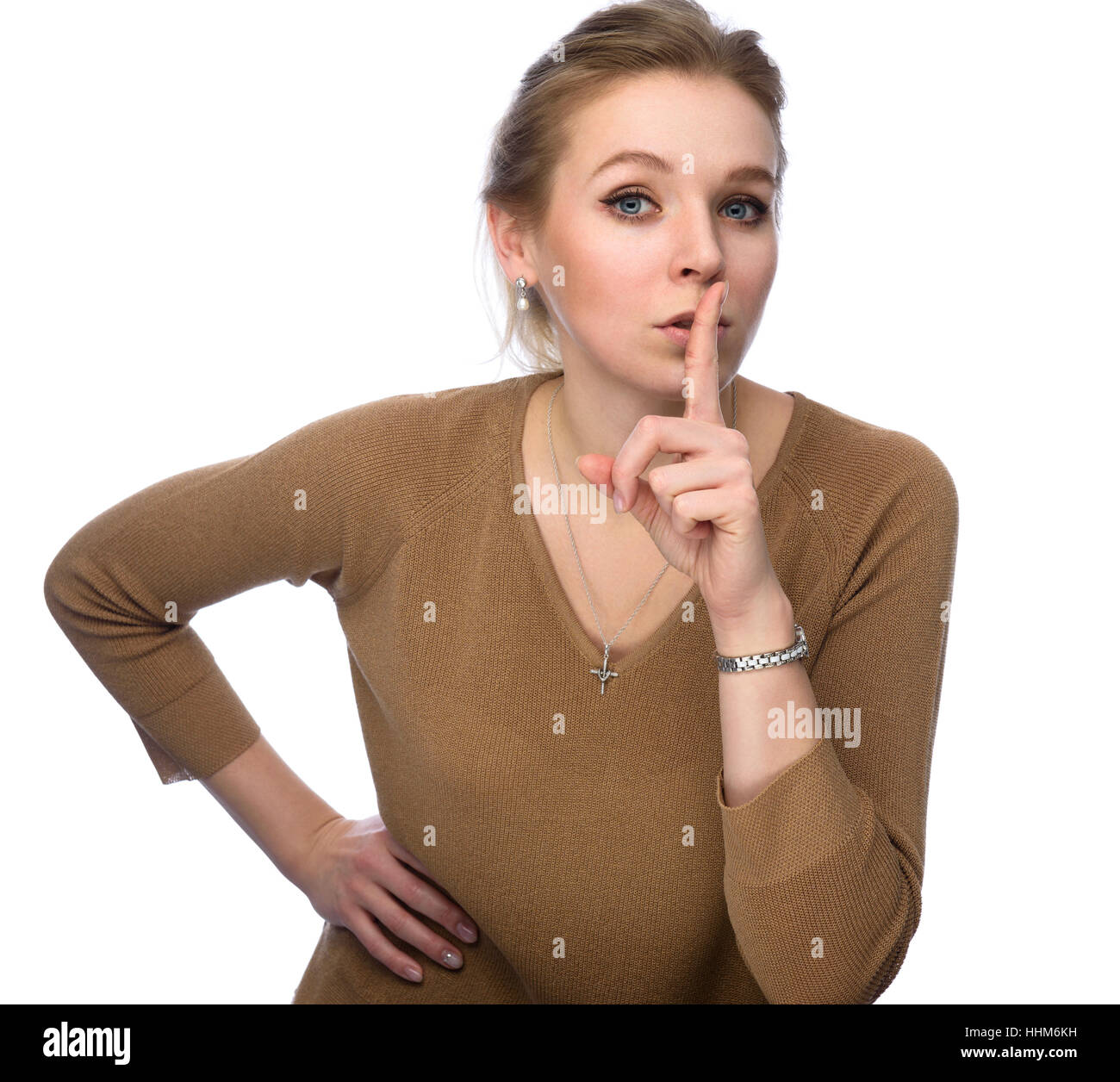Young woman keeping her forefinger by lips. Isolated Stock Photo - Alamy