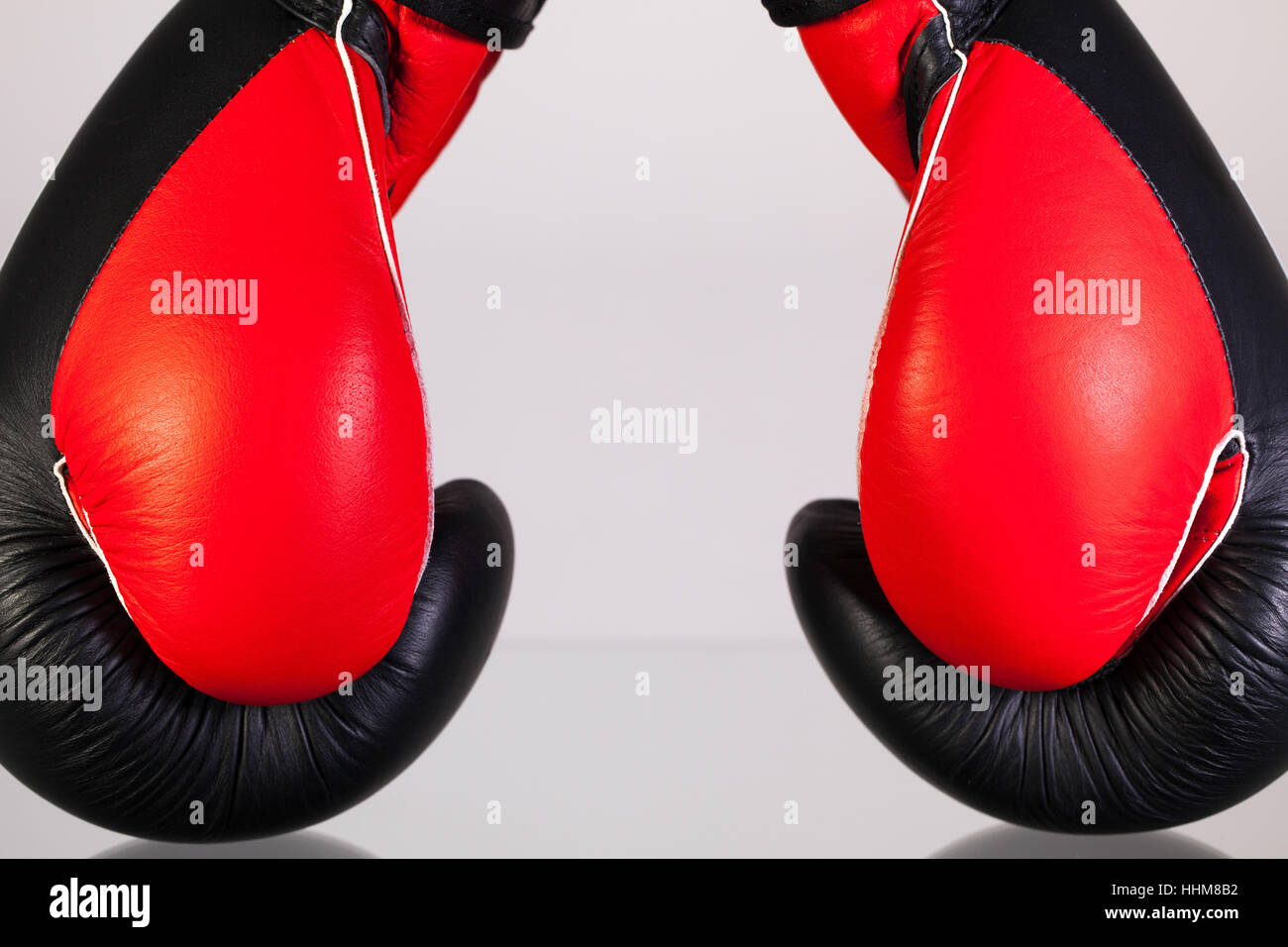 Red and black boxing gloves on a glass table isolated on white ...