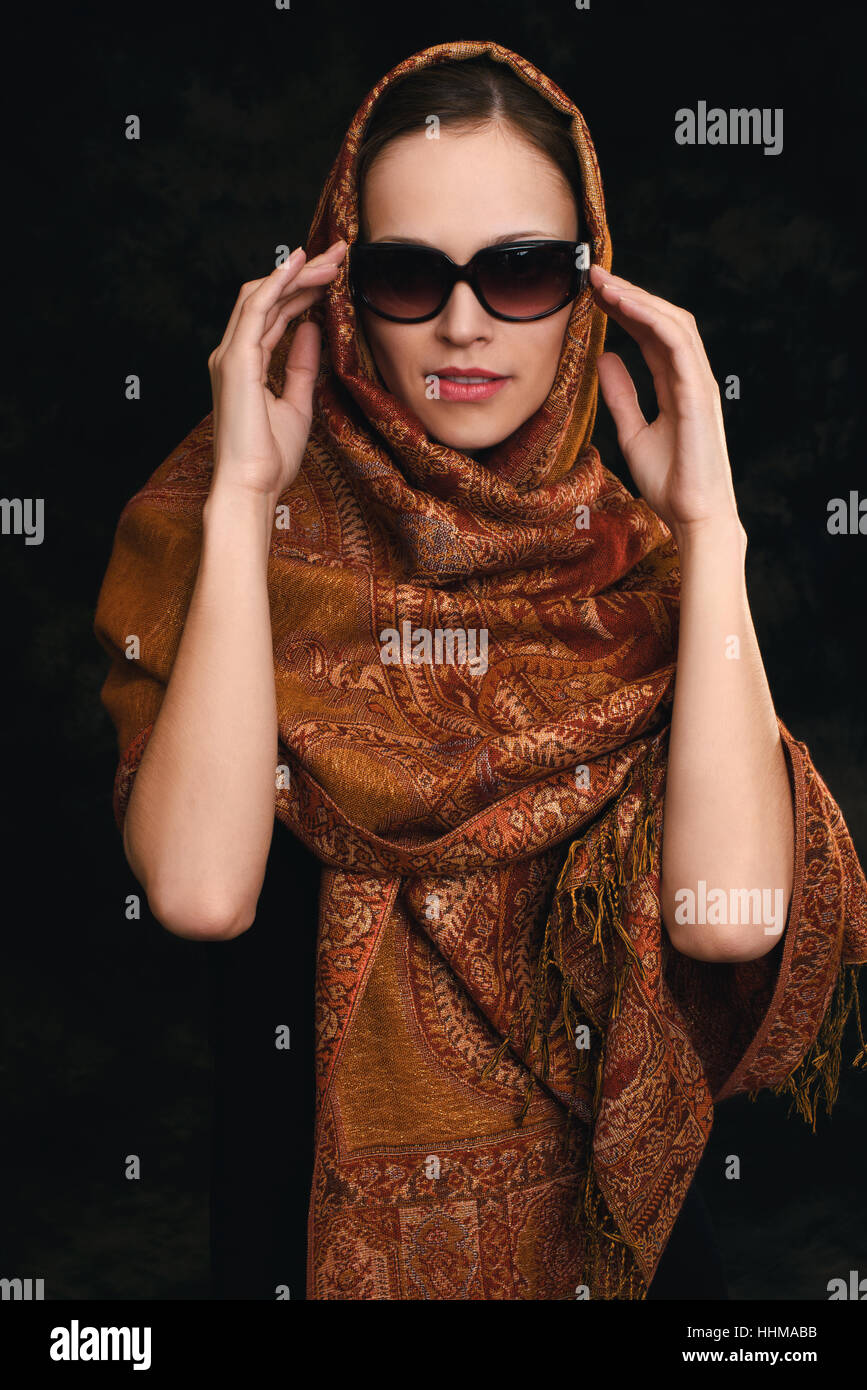 beautiful arabic caucasian woman wearing sunglasses. Dark background ...