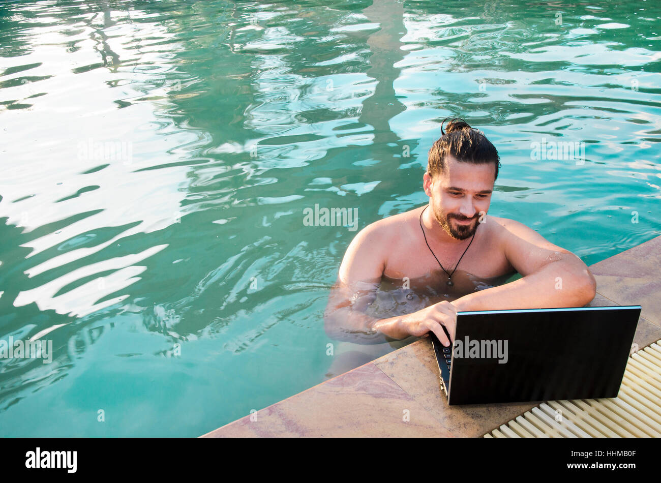 Working on laptop from the swimming pool Stock Photo - Alamy