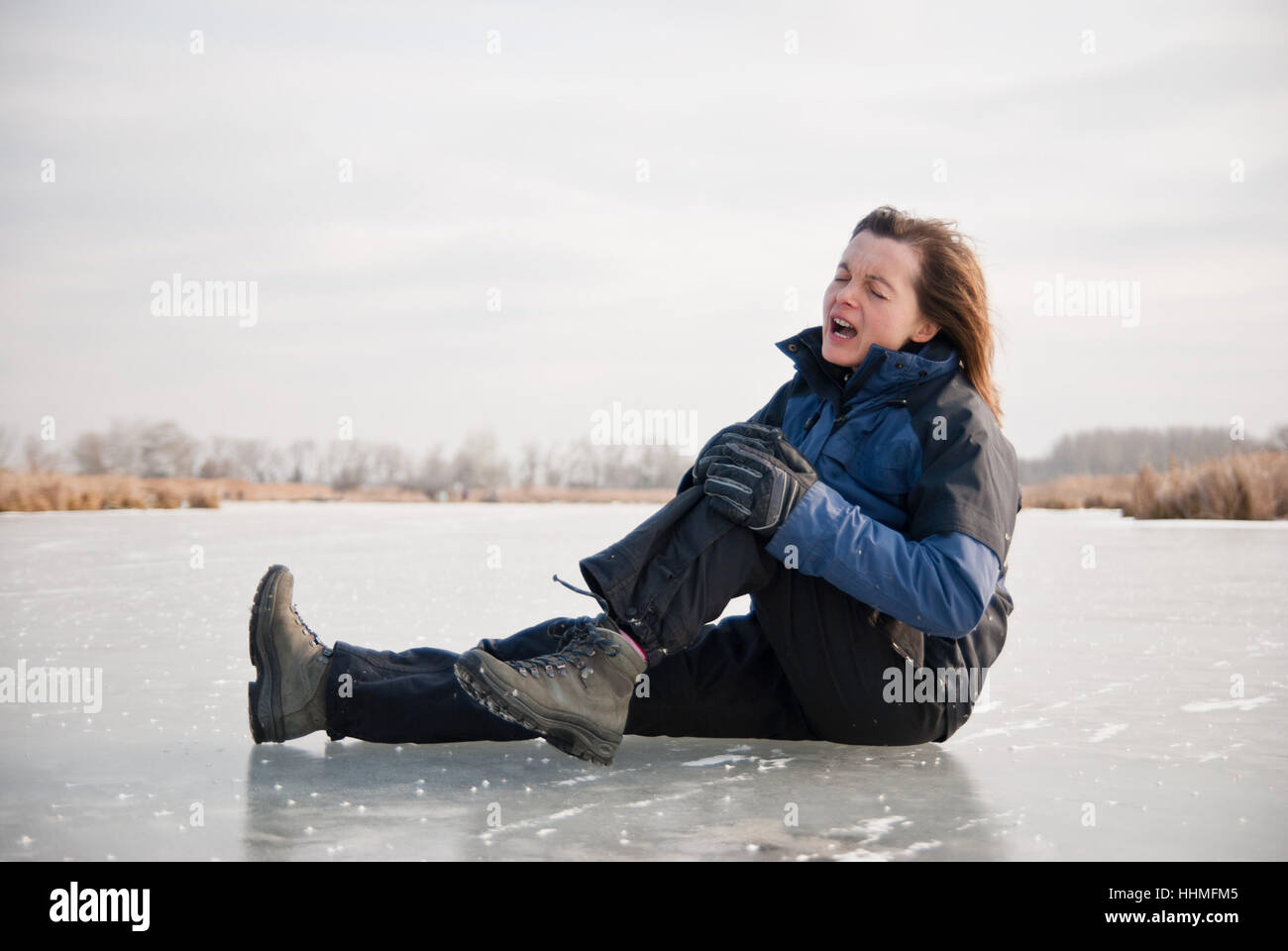 Young woman with knee injury on frozen icy lake Stock Photo - Alamy