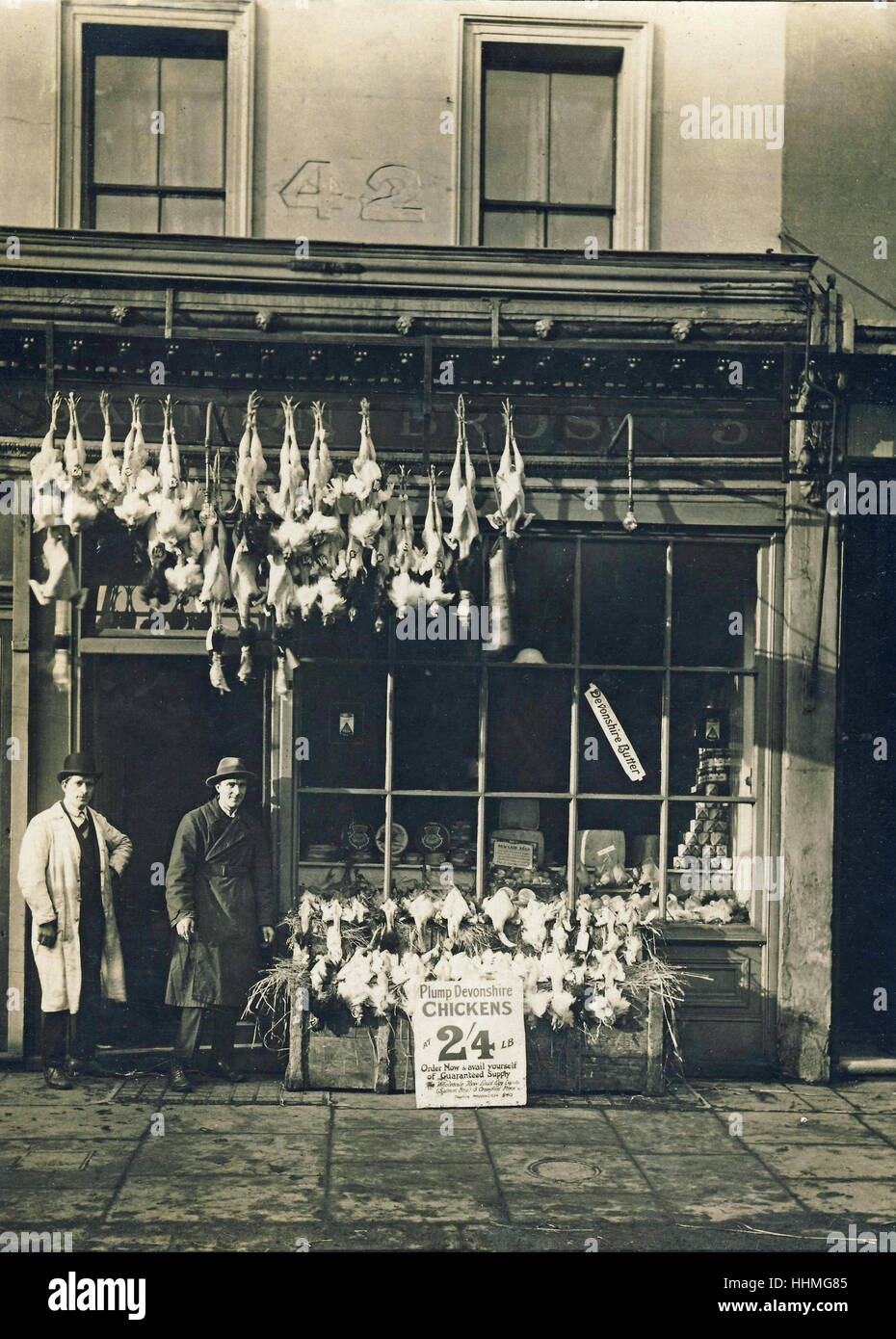 Historic archive image of men outside poulterer's shop in London. With ...