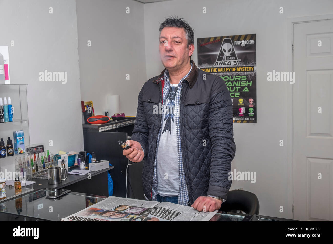 A Vape shop owner showing how to vape a e-cigarette Stock Photo - Alamy