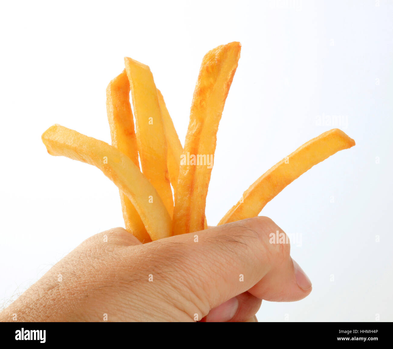 Man's hand holding French fries - closeup Stock Photo - Alamy