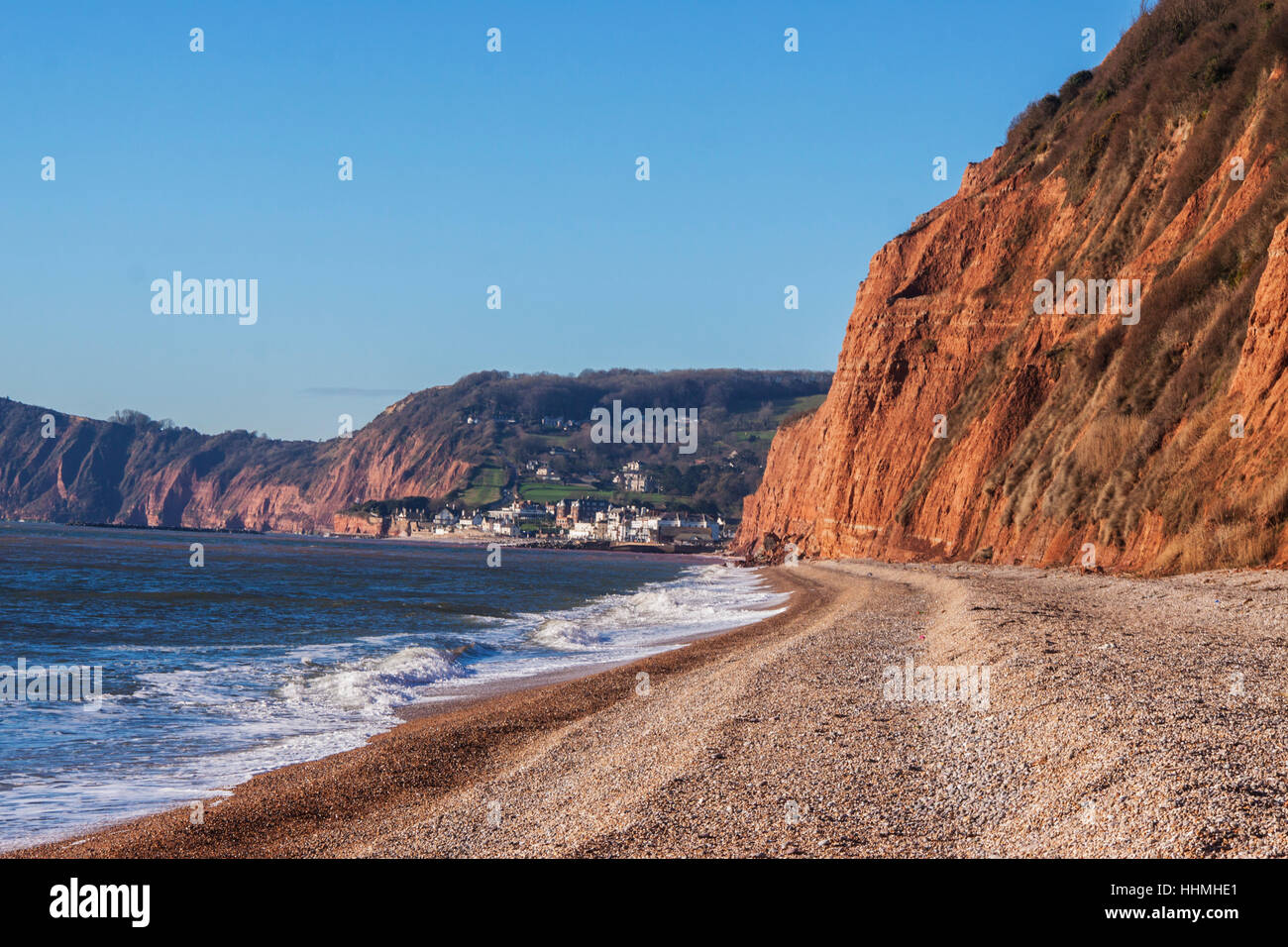 The pebble shingle beach and dangerous, eroding red sandstone cliffs at ...
