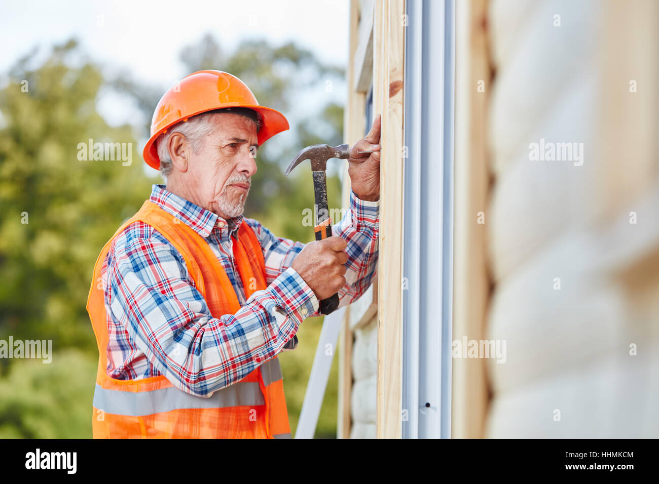 Senior citizen as building construction craftsman working on new house ...